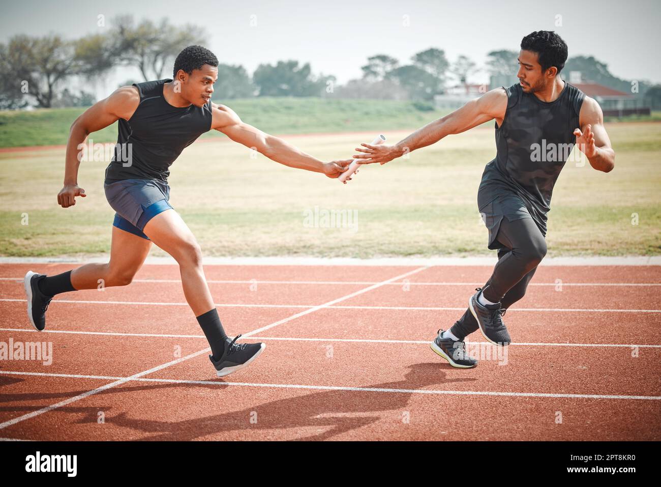 The handover. Full length shot of a handsome young male athlete ...