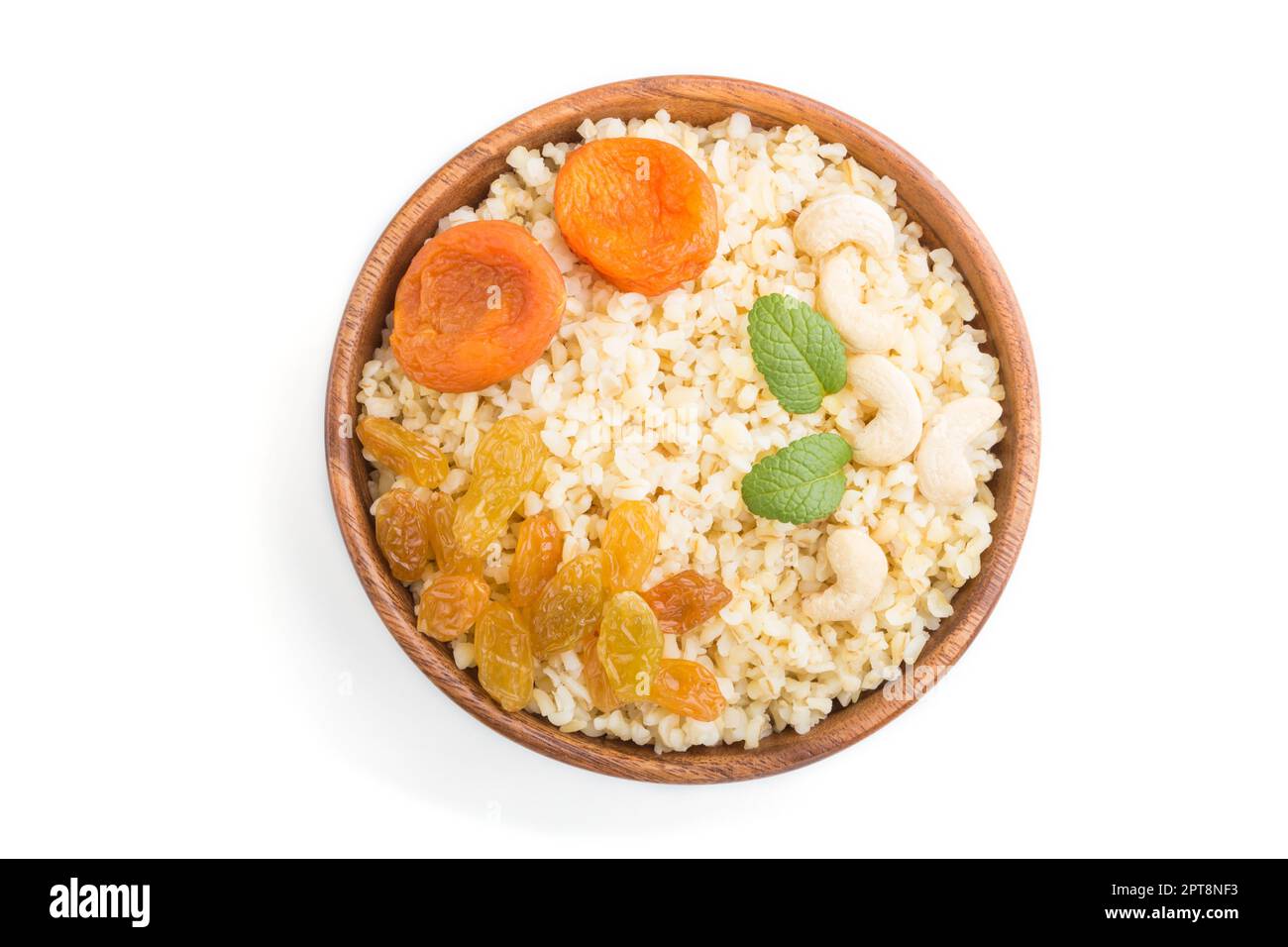 Bulgur porridge with dried apricots, raisins and cashew in wooden bowl ...