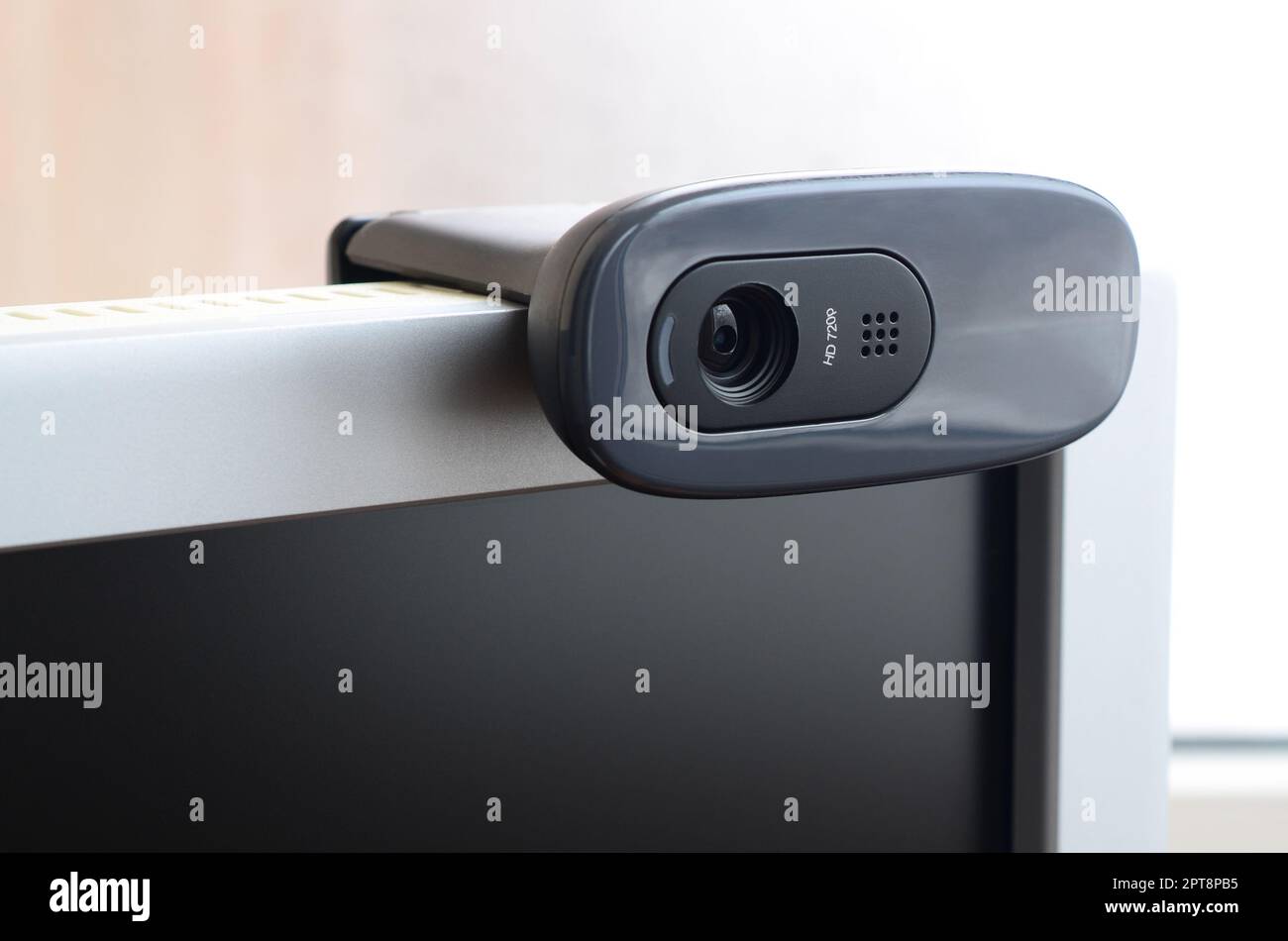 A modern web camera is installed on the body of a flat screen monitor ...