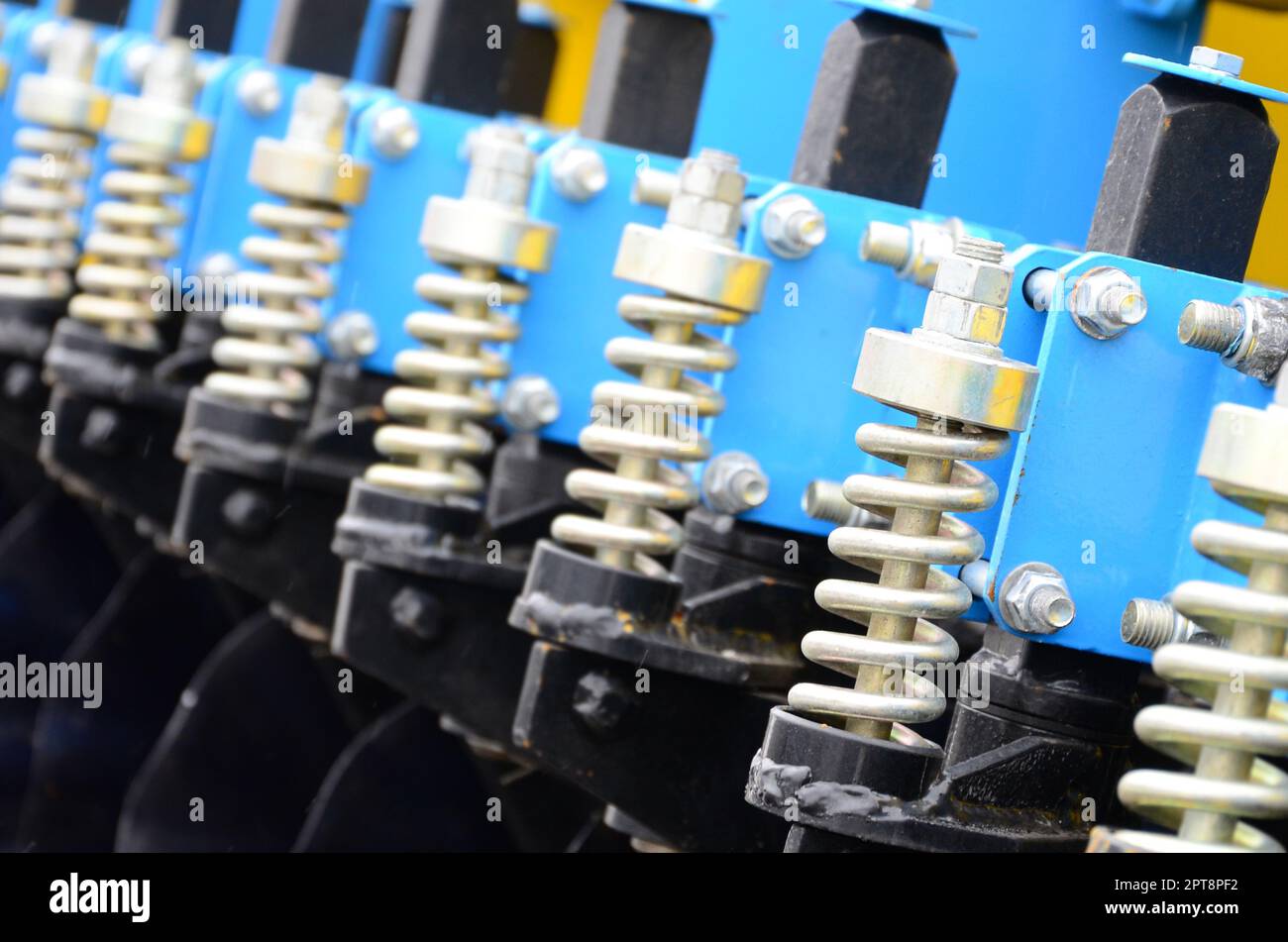 Spring system of agricultural seeder close up Stock Photo - Alamy