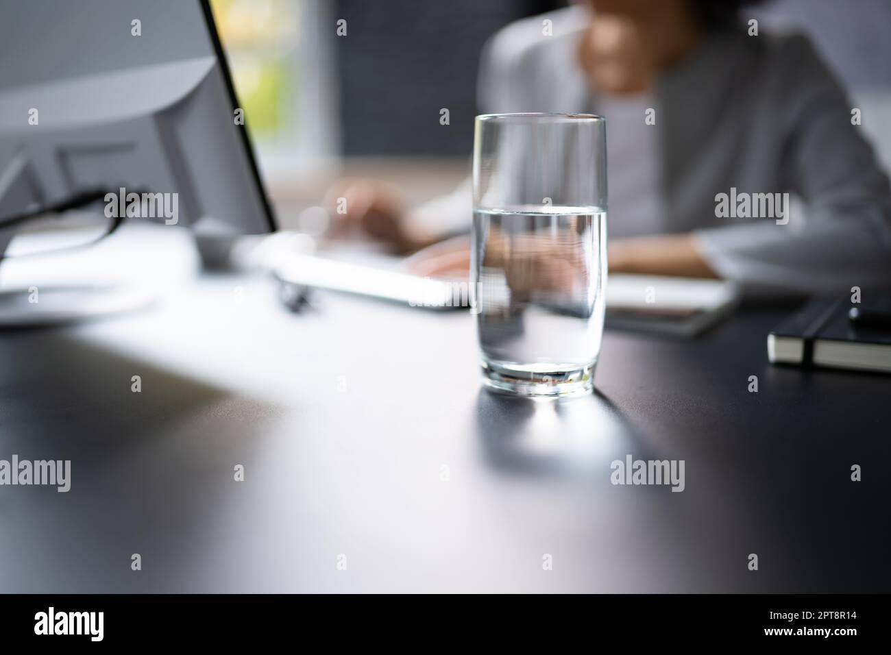 Glass Of Water Near African American Typing On Computer Stock Photo - Alamy