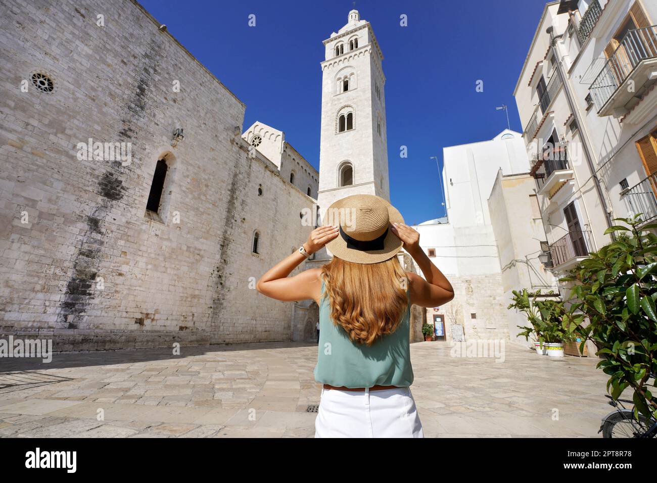 Tourism in Apulia. Back view of tourist girl exploring the historic ...
