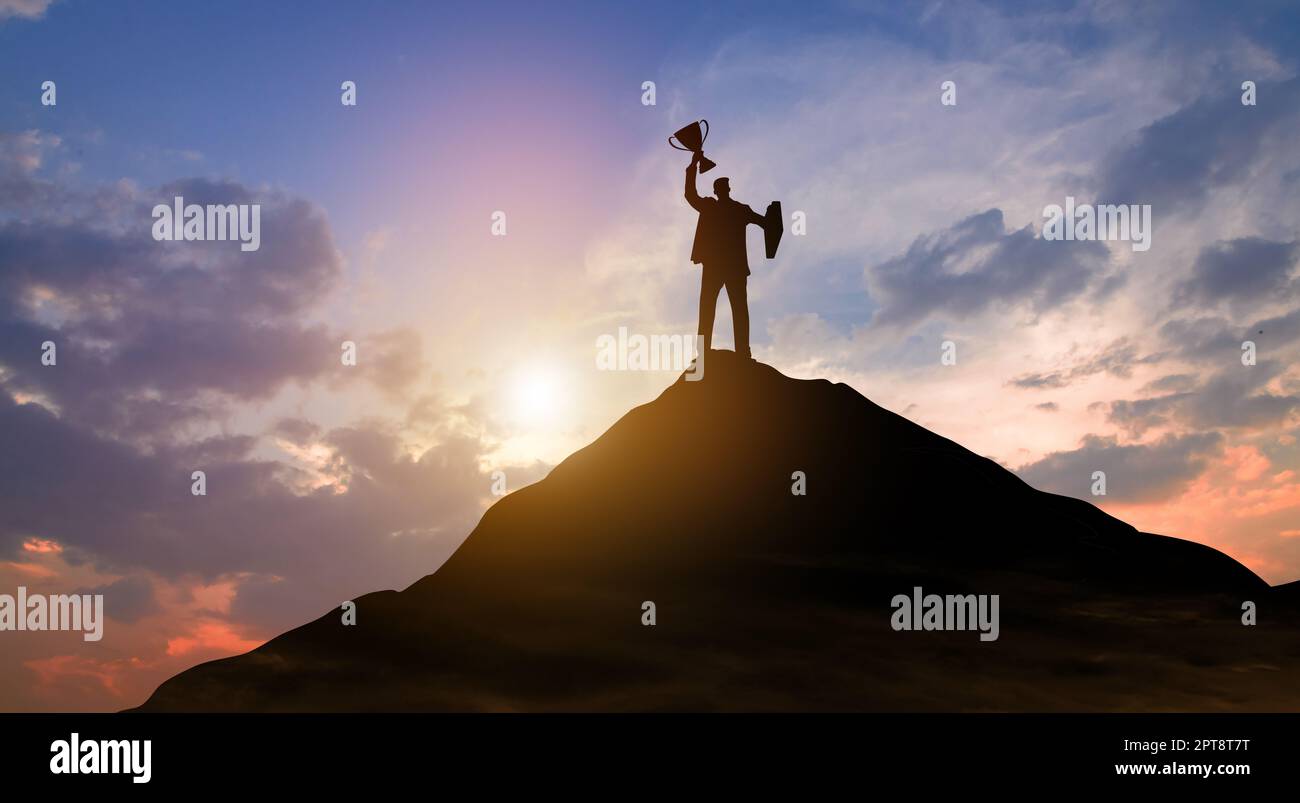 Silhouette victory businessman with trophy climbed to the top of ...