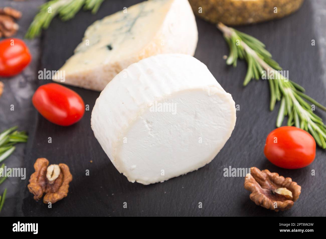 White goat cheese and various types of cheese with rosemary and ...