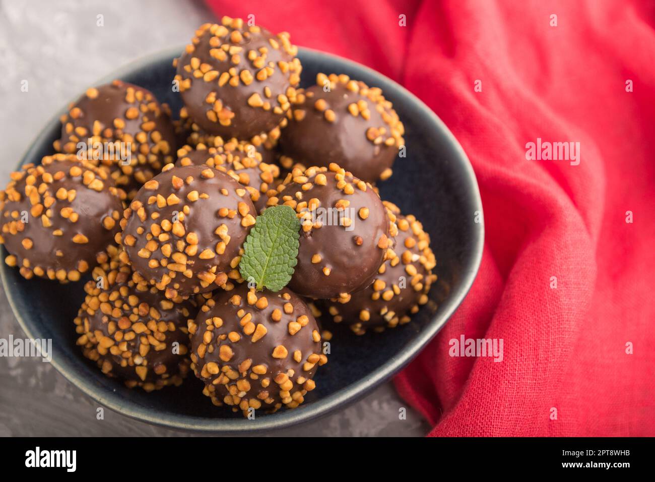 Chocolate caramel ball candies with almonds and a cup of coffee on a ...