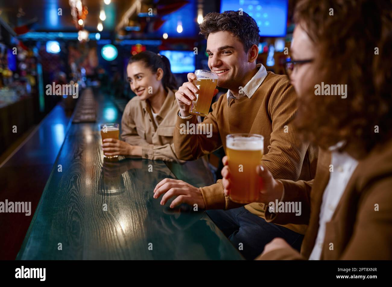 Happy friends resting and talking at the bar. Group of excited people ...