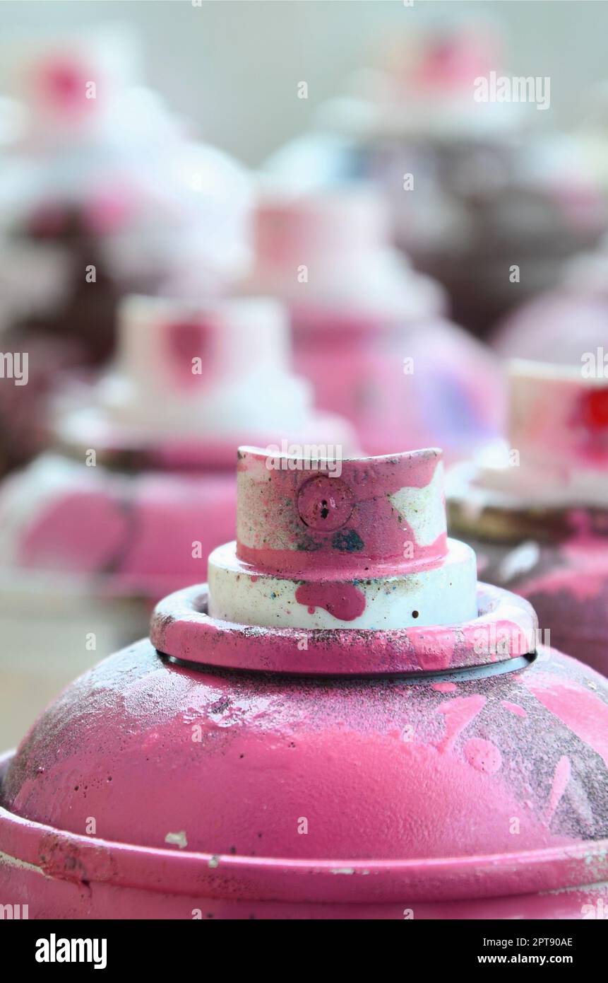 A lot of dirty and used aerosol cans of bright pink paint. Macro ...
