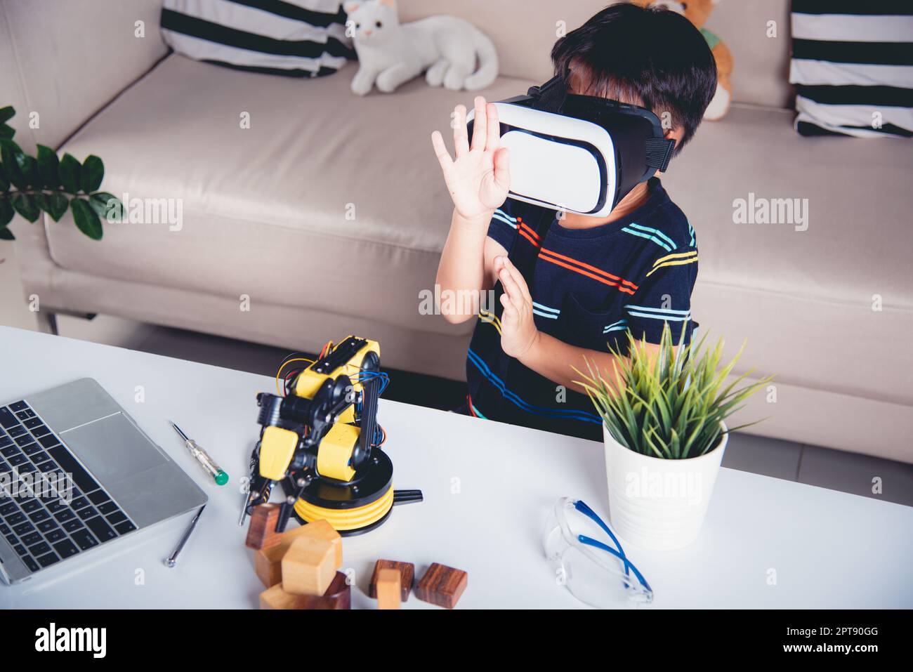 Virtual Reality Simulator. Asian kid boy using VR glasses on robotic ...