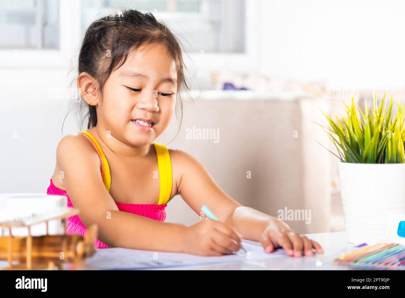 Asian cute kid preschooler sitting on table smiling she draw and ...