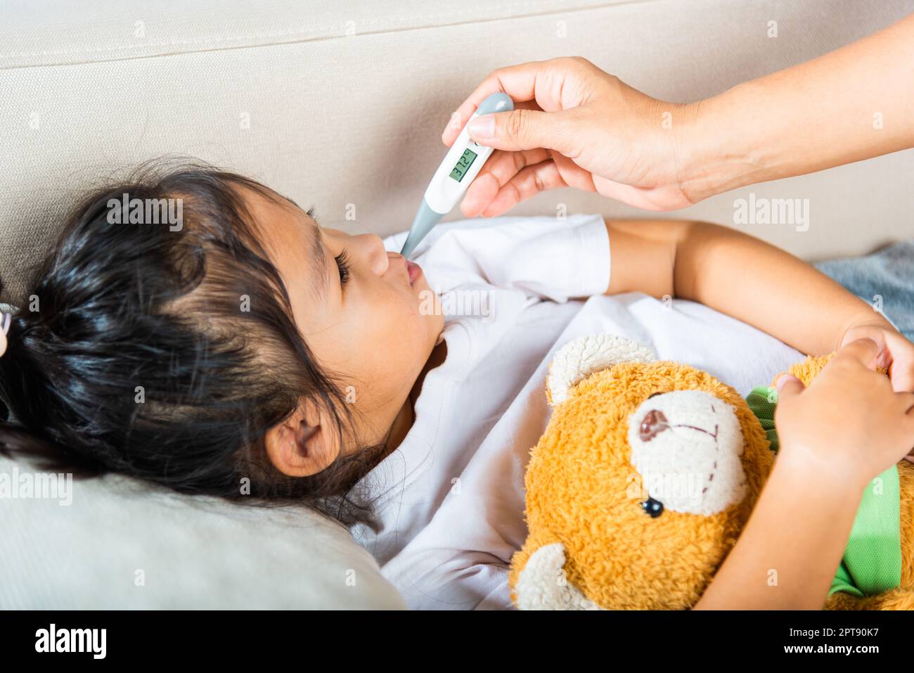 Sick kid. Mother checking temperature of her sick daughter with thermometer in mouth, child ...