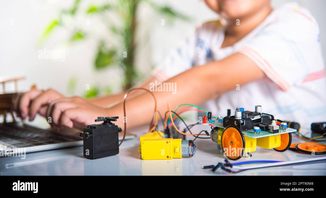 Asian kid boy learns coding and programming with laptop for Arduino robot car, Little child ...