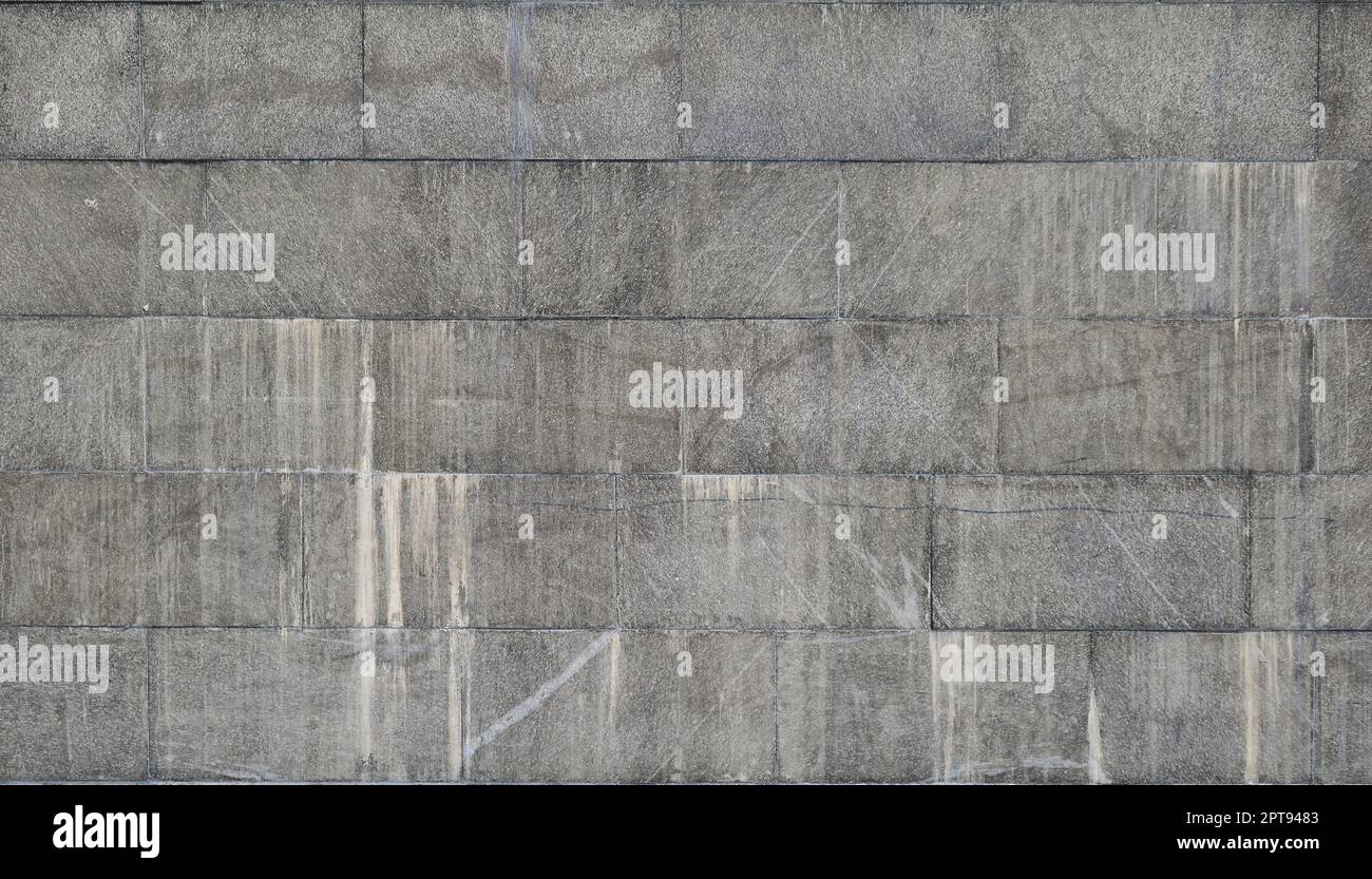 The texture of a wall of large granite tiles that are covered with ...