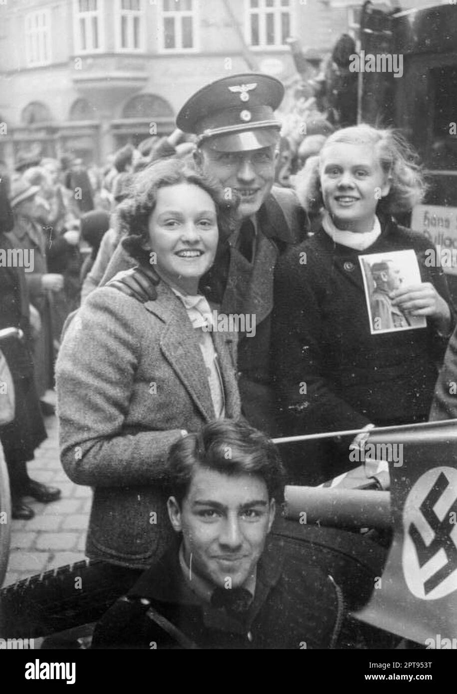 A German soldier poses with two happy young women during the ...