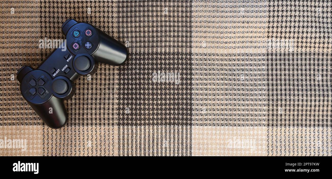 Close-up photo of a black plastic wireless game controller on a ...