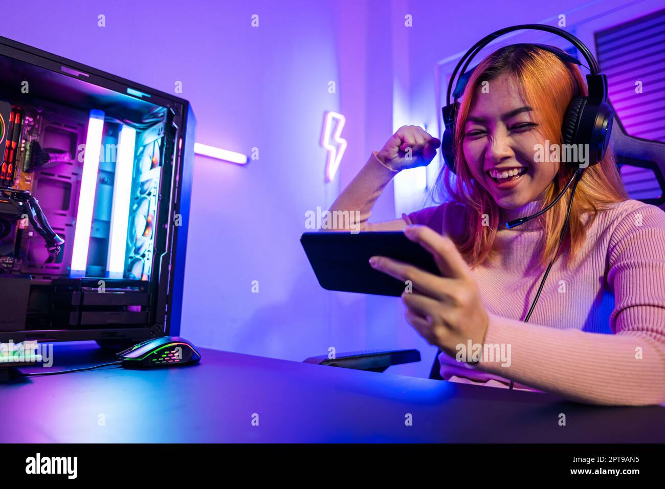 Winning. Happy Gamer playing video game online with smartphone with ...