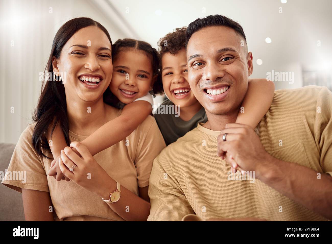 Hug, children and parents on the sofa in the living room of house for ...