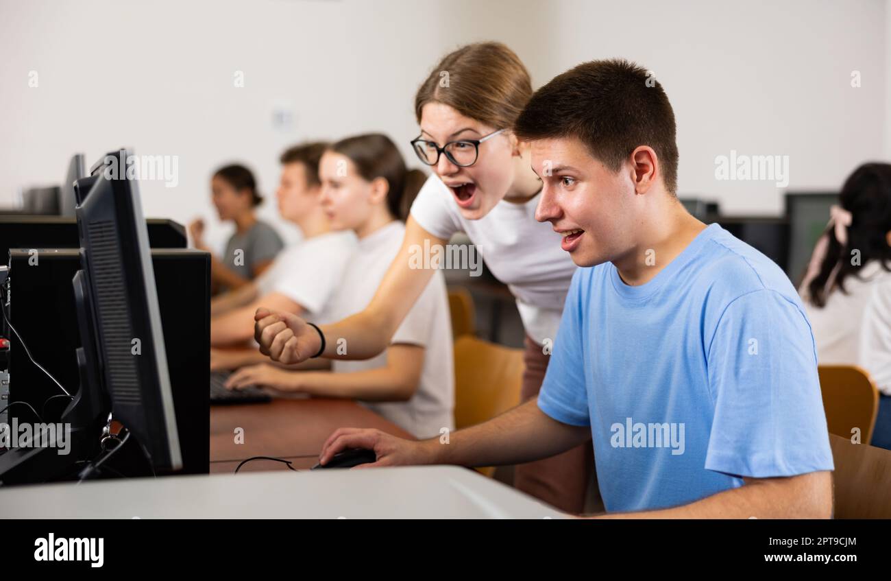 Positive toung boy and girl playing videogame in computer class Stock ...