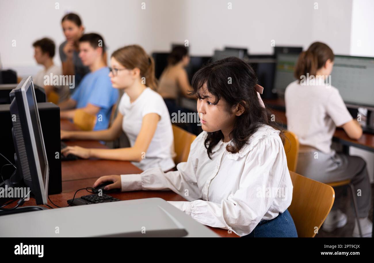 Teenage girl using computer during lesson Stock Photo - Alamy