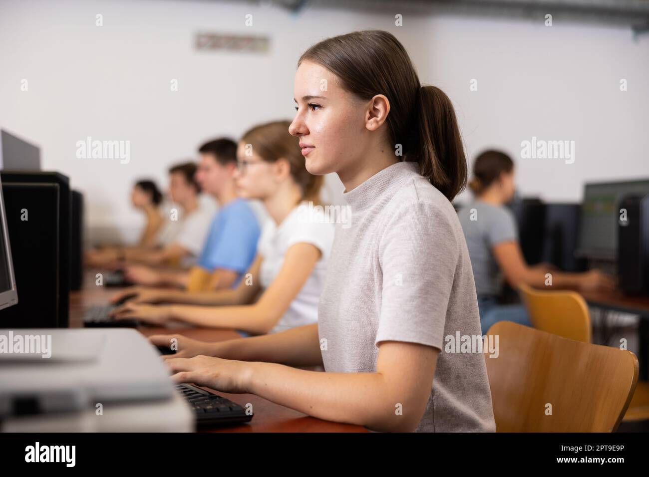 Focused female teenager solving tasks of computer science in the ...