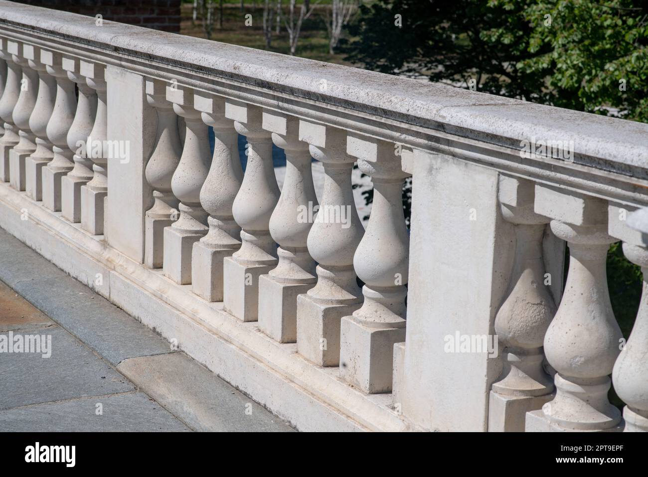 park with a white marble balustrade in the background green plants give ...