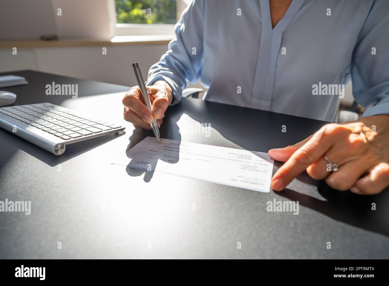 Writing Cheque. Signing Paycheck Or Money Check Stock Photo - Alamy