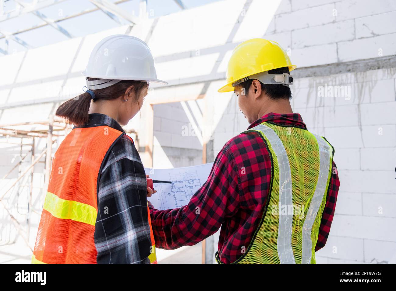 Architect and client discussing the plan with blueprint of the building ...