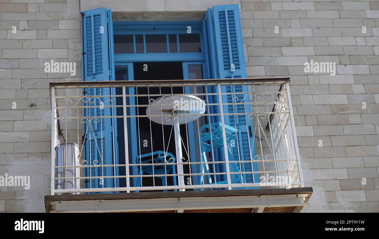 A balcony with blue shutters, and a wrought iron railing Stock Photo ...