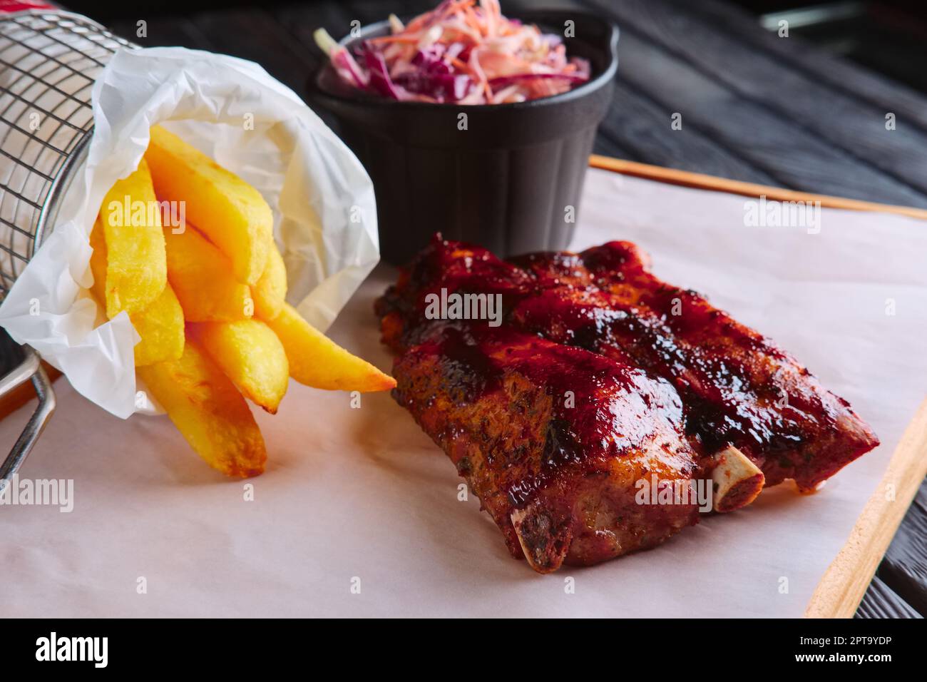 Rustic lunch. Grilled ribs with fried potato and red cabbage salad ...