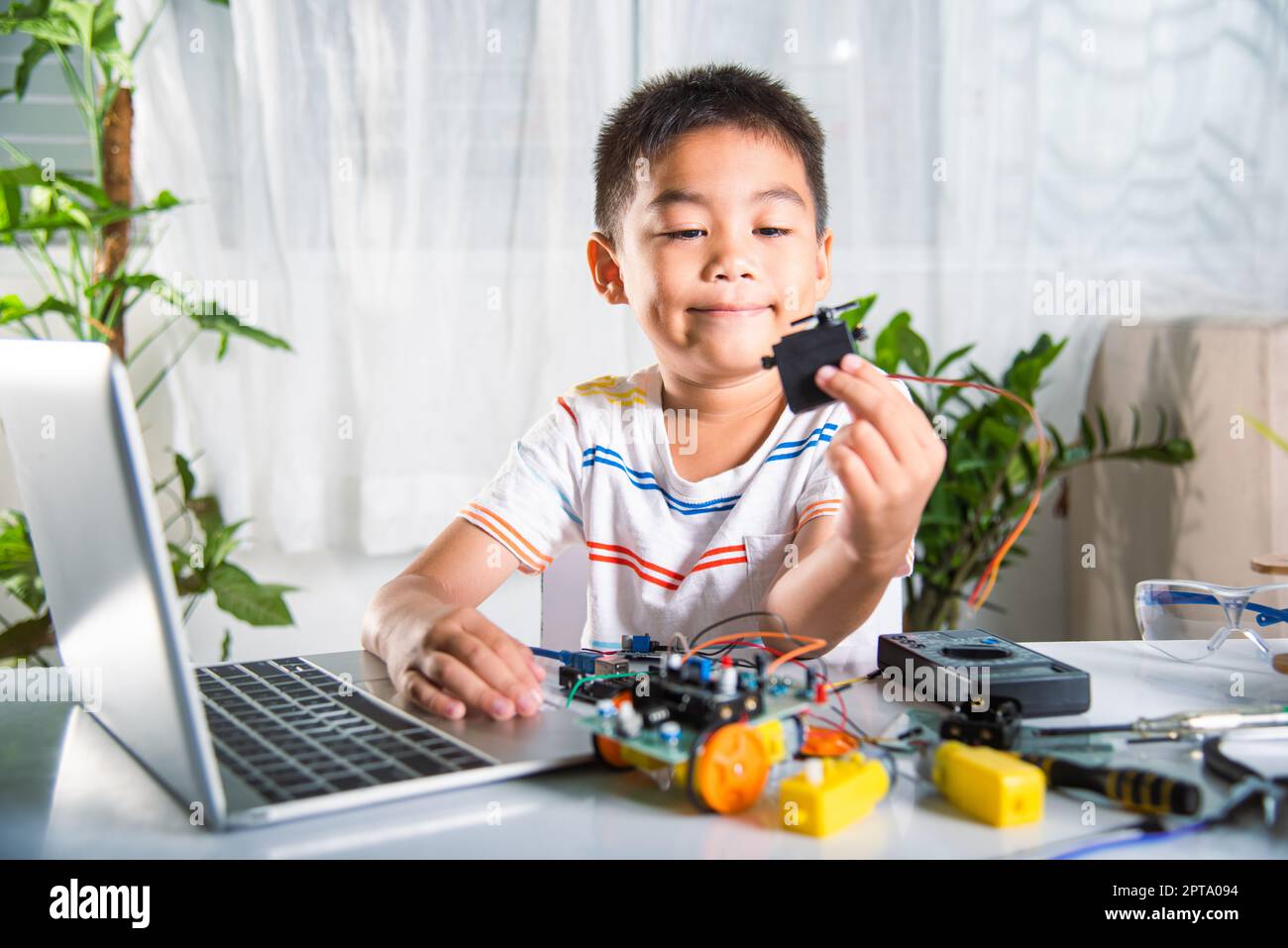Little student child holding stepping motor to assemble car toy, Asian ...