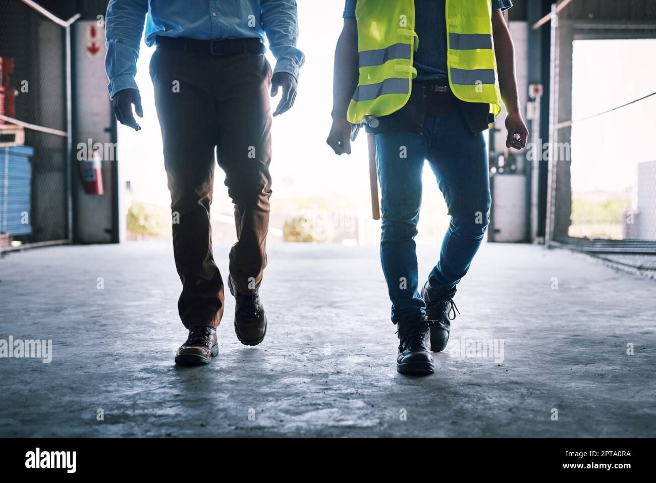 Progress is a process. two unrecognisable builders walking through a ...