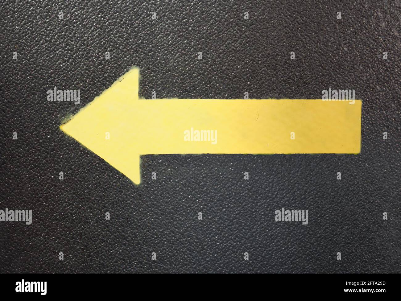 left arrow direction sign yellow paint on glass Stock Photo - Alamy