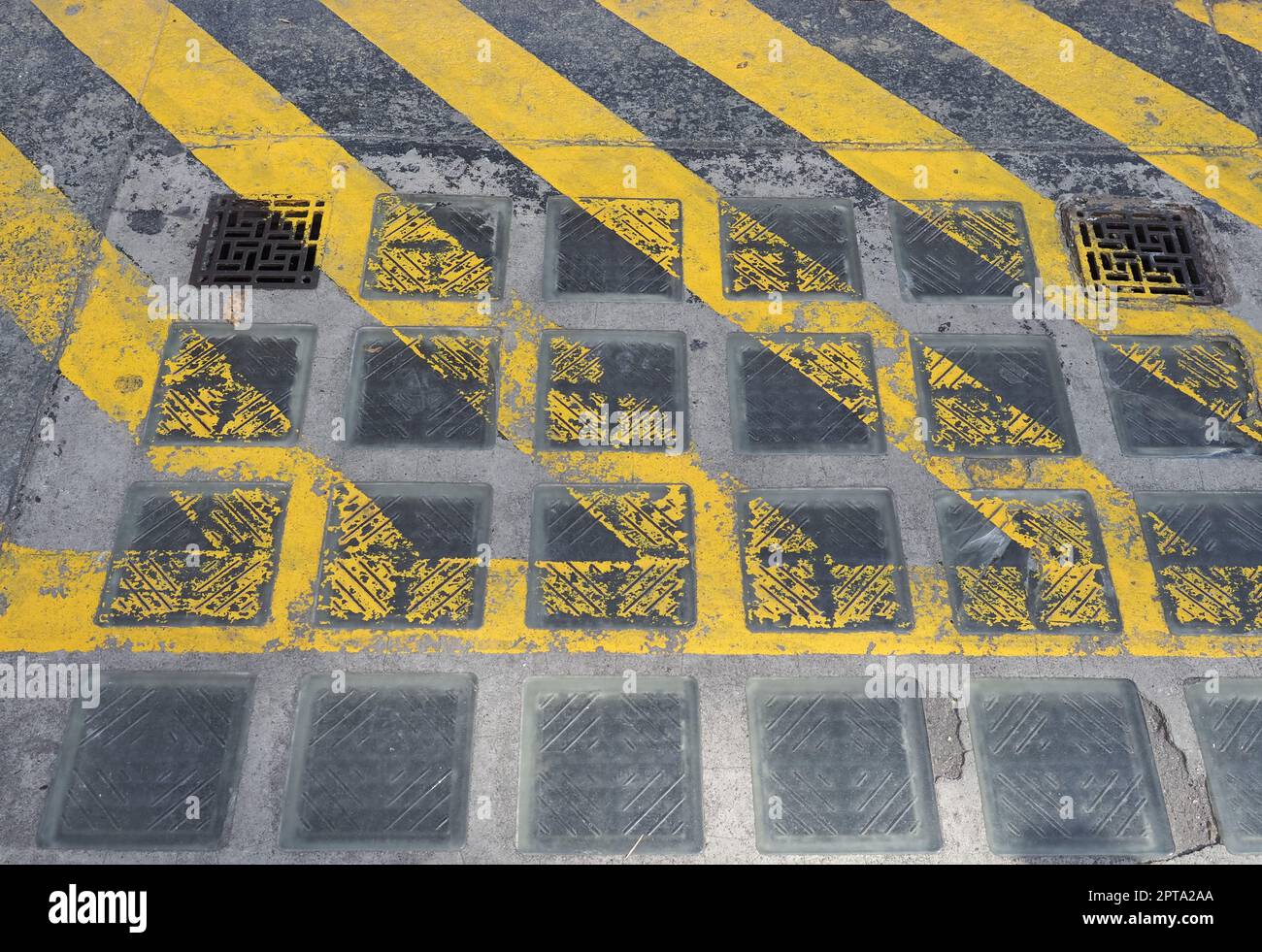 yellow lines warning sign painted on pavement Stock Photo - Alamy
