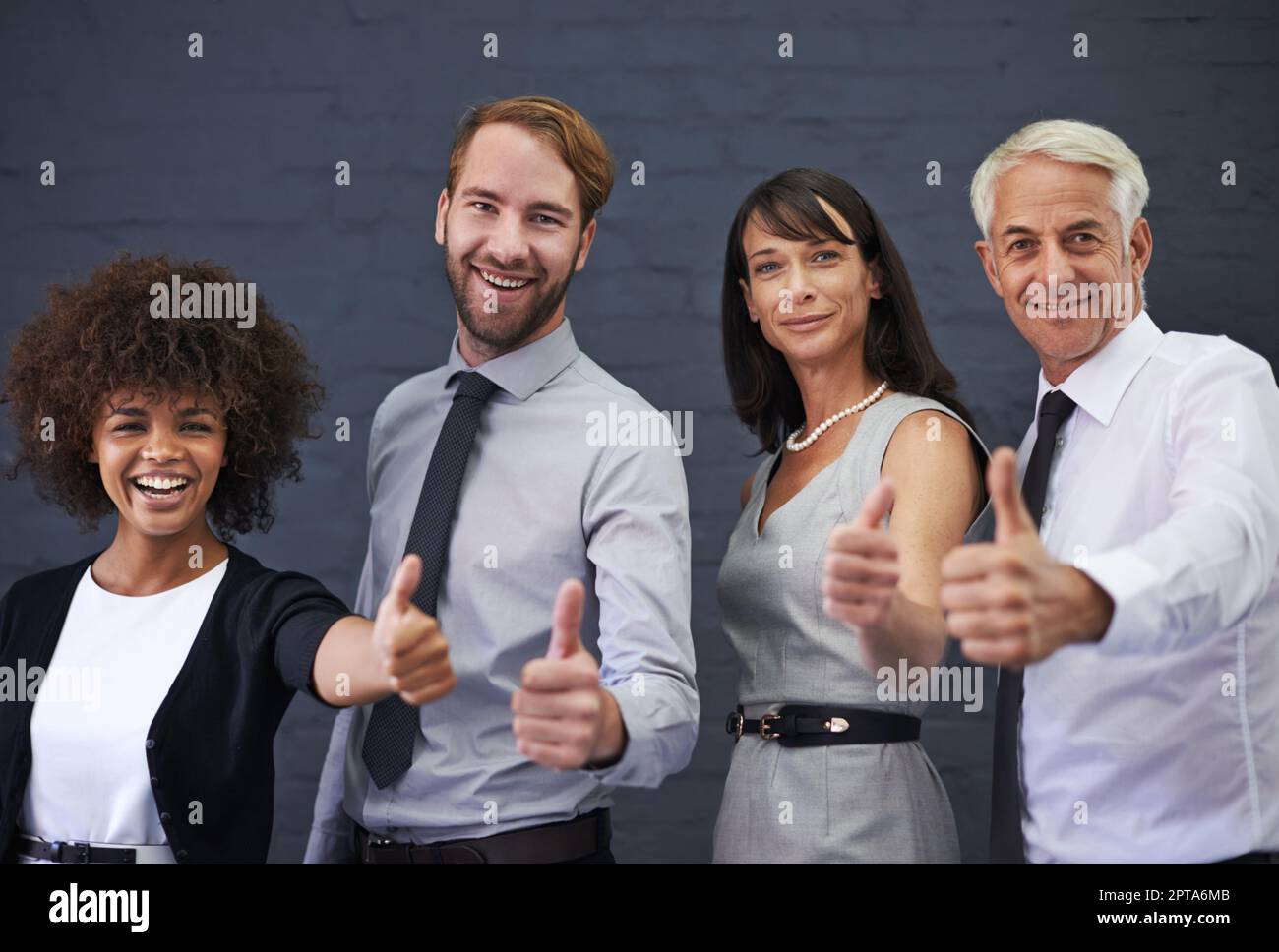 Go for gold. Portrait of a group of professional coworkers giving ...