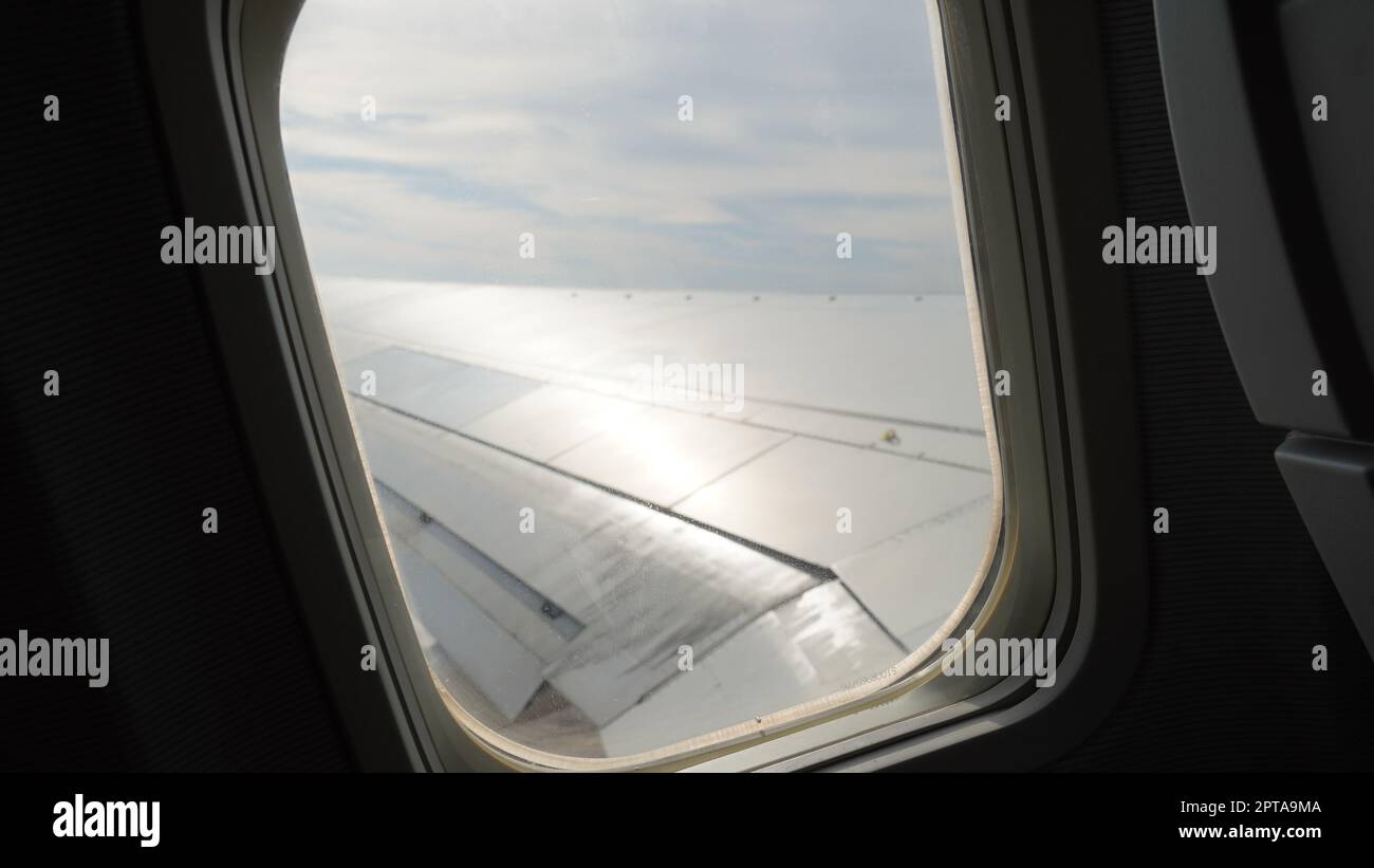 Wing of an airplane, passenger s view. Looking through the window of a ...