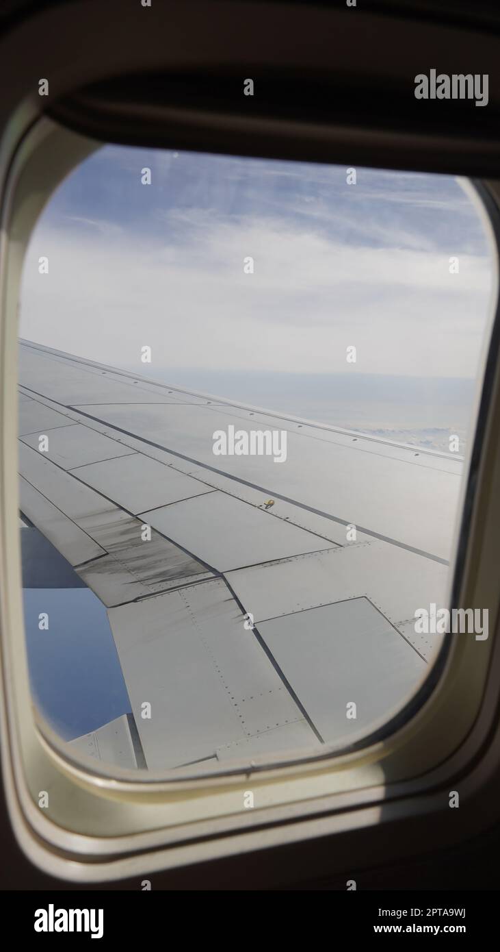 Wing of an airplane, passenger s view. Looking through the window of a ...