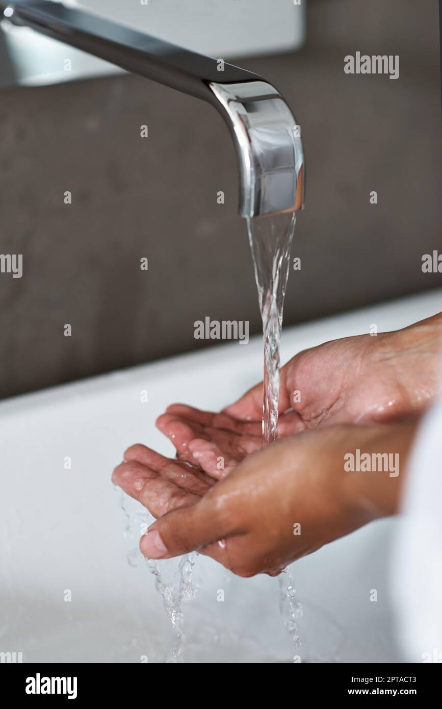 The cleansing powers of water. a woman washing her hands under a tap ...
