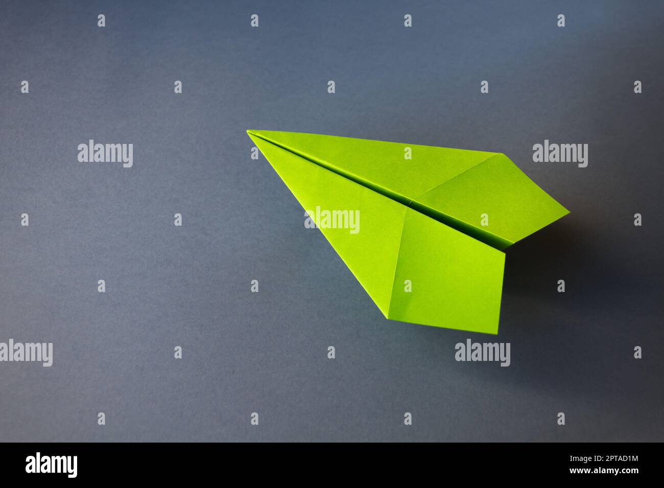Green paper plane origami isolated on a blank grey background Stock ...