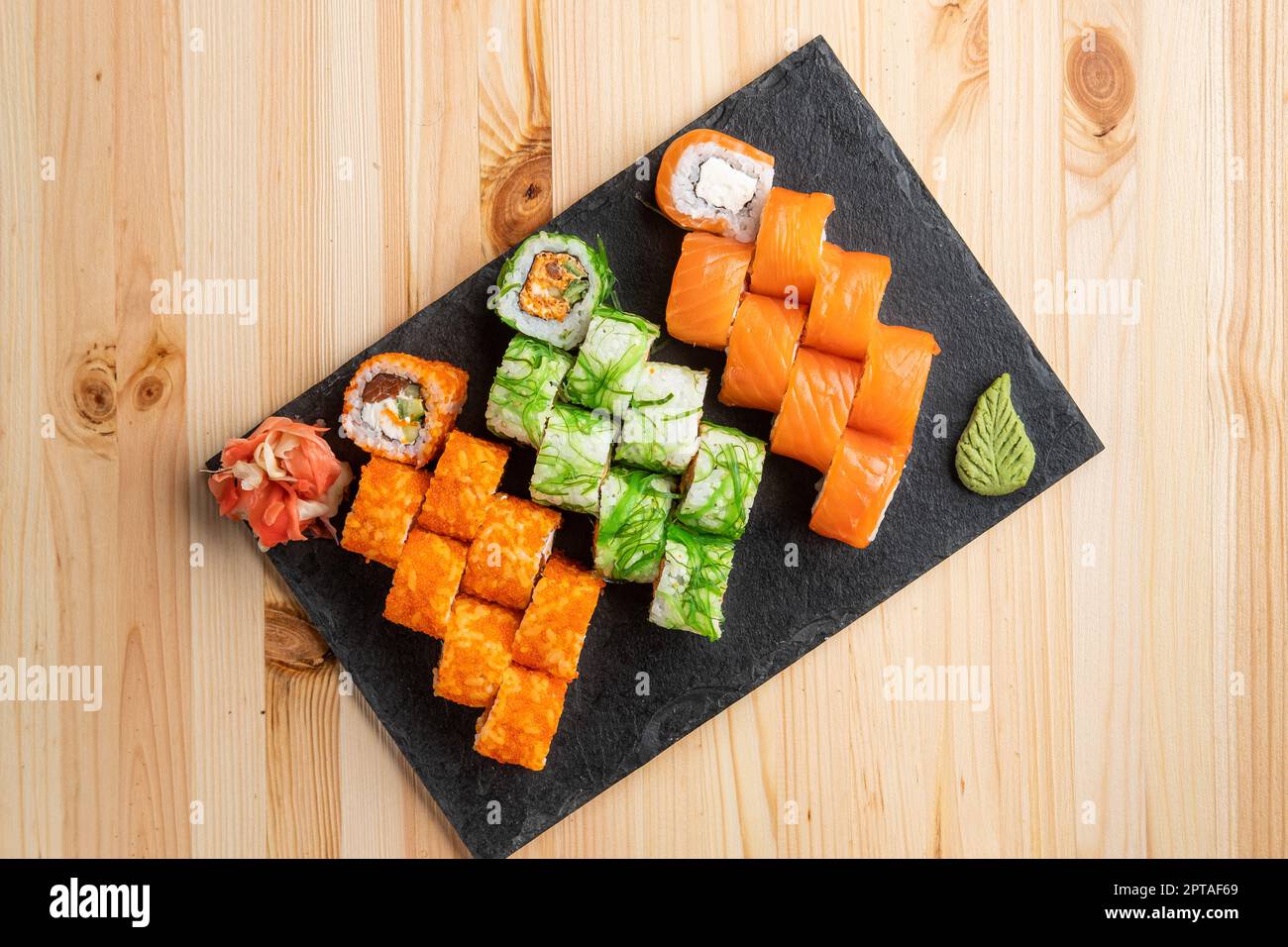 Set of rolls with wasabi and pickled ginger on stone serving board ...