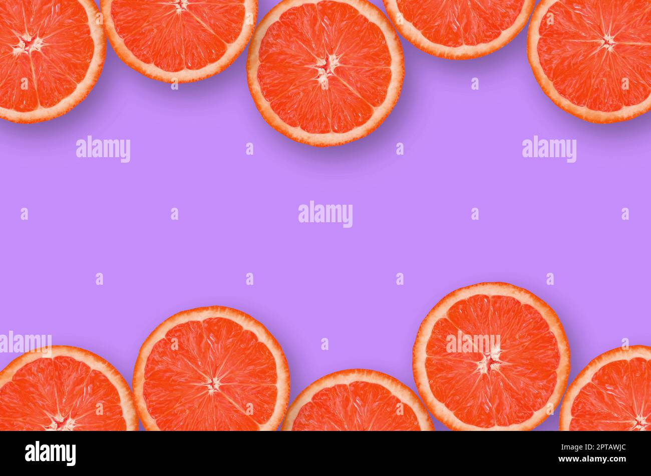 Top view of grapefruit slices on bright purple background. A saturated ...