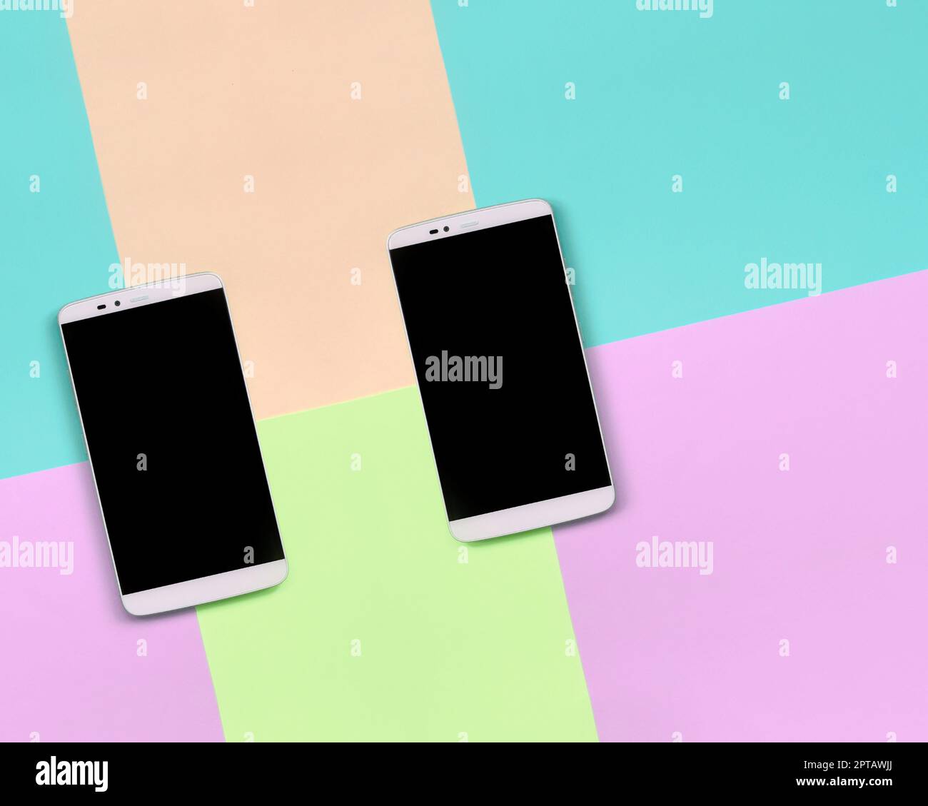 Two modern smartphones with black screens on texture background of ...