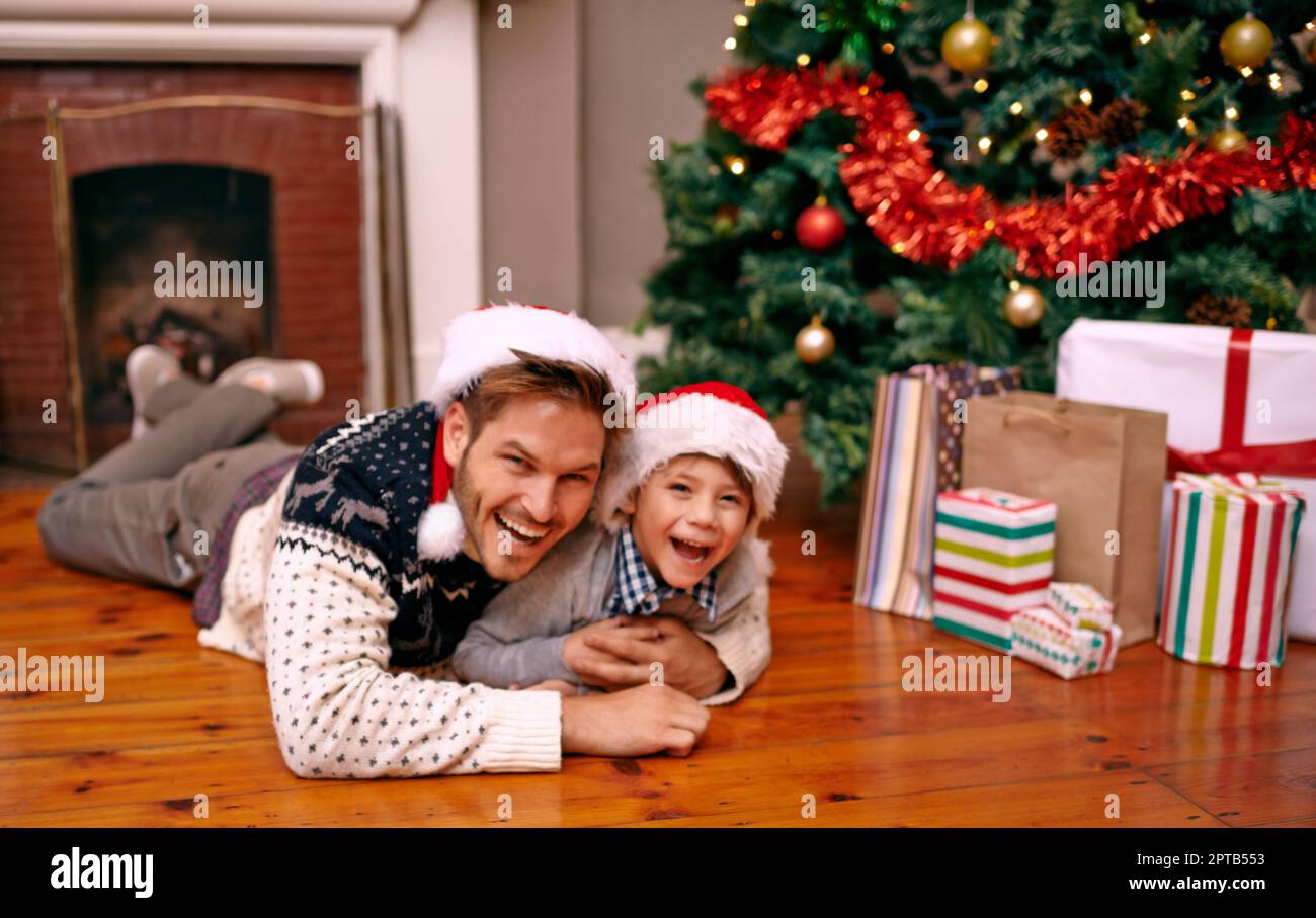 Waiting to ambush Santa...A young boy and his father lying on the floor ...