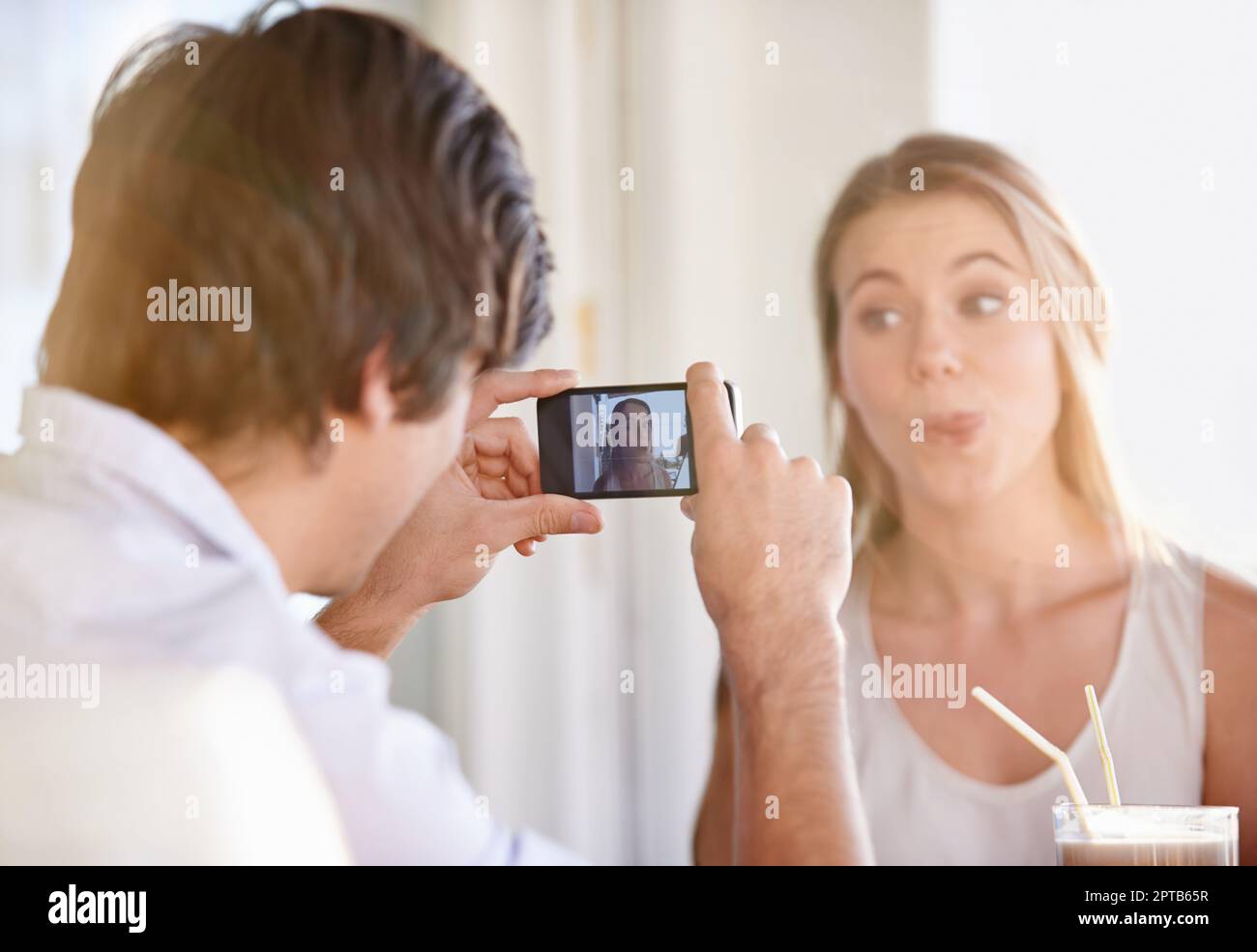 Lets do a fun one. A young man snapping a picture of his girlfriend ...