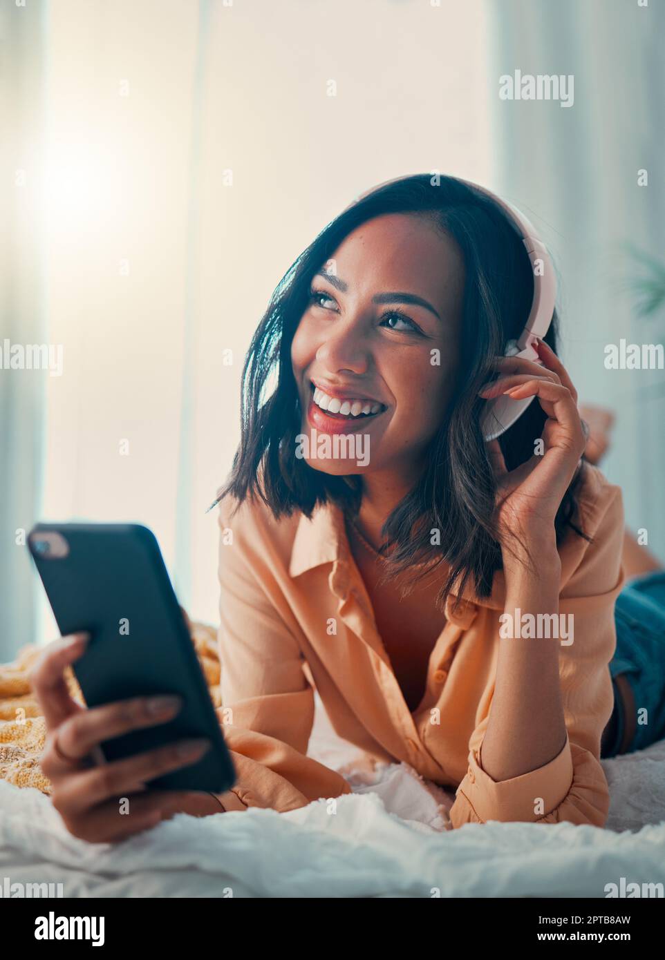 Music, smartphone and relax black woman on bed streaming radio song ...