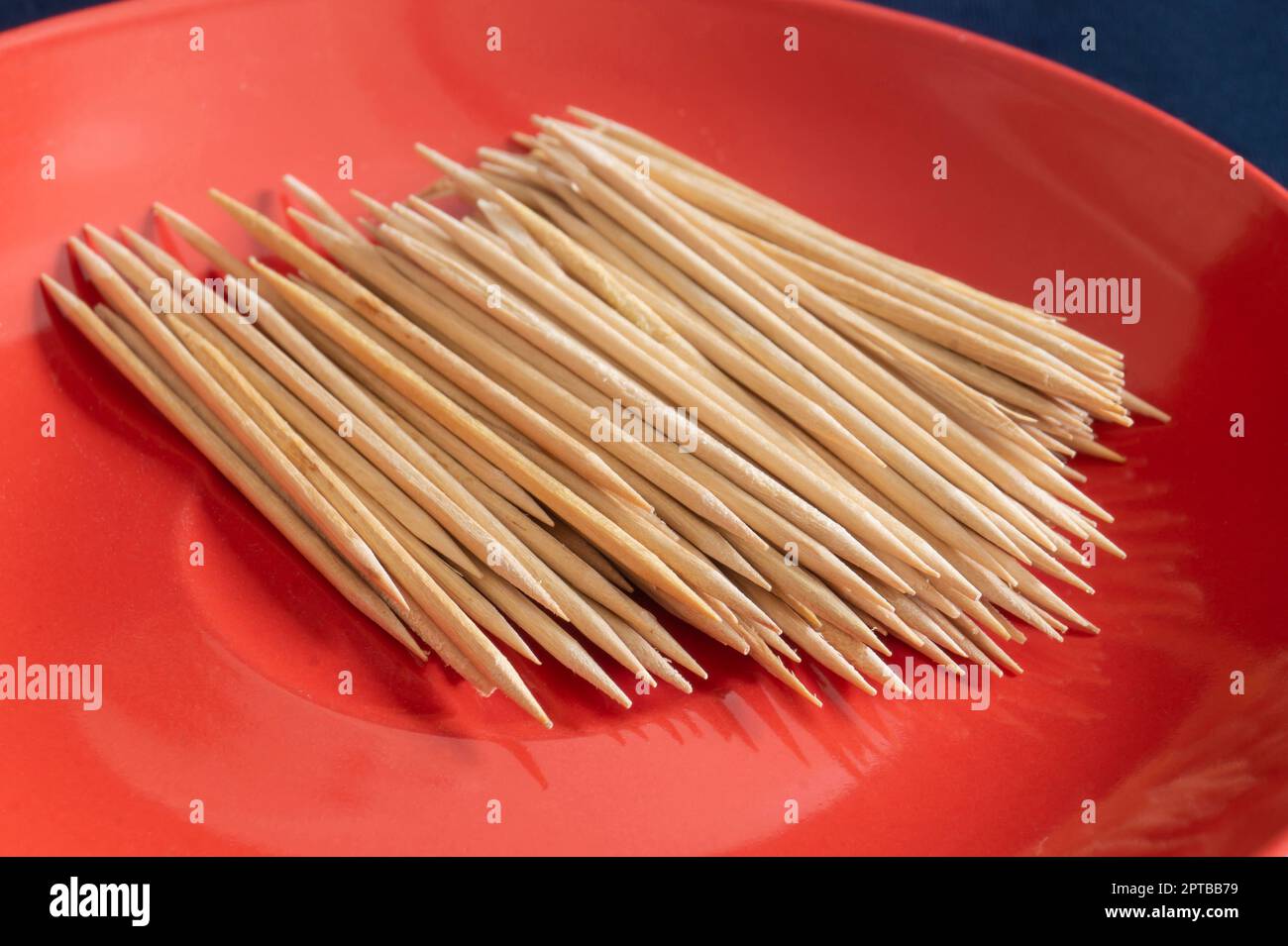 Wooden toothpicks on a red background. A sharp object for brushing ...