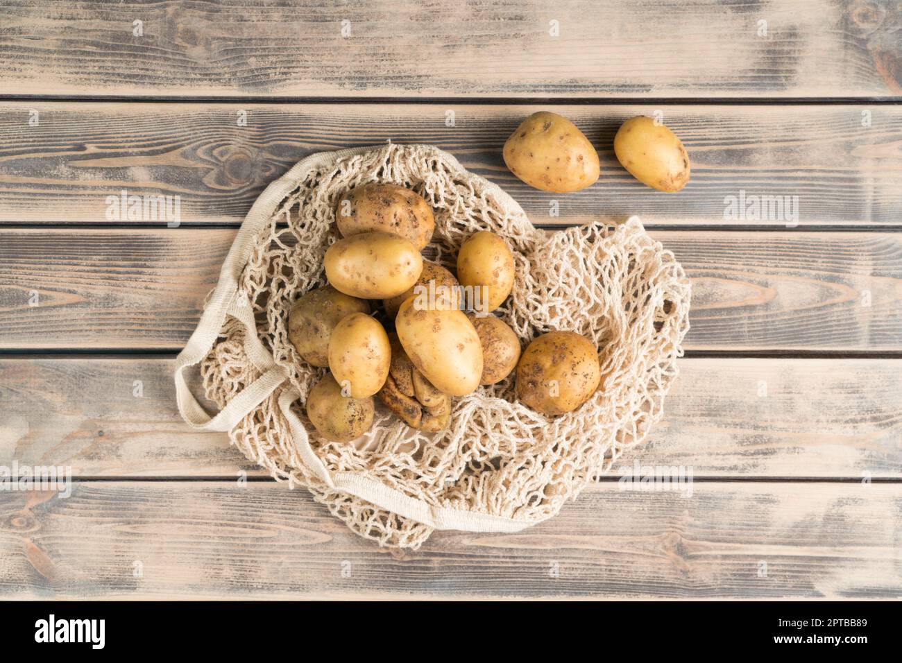Bunch of unpeeled yellow new potatoes on faded wooden table, top view ...