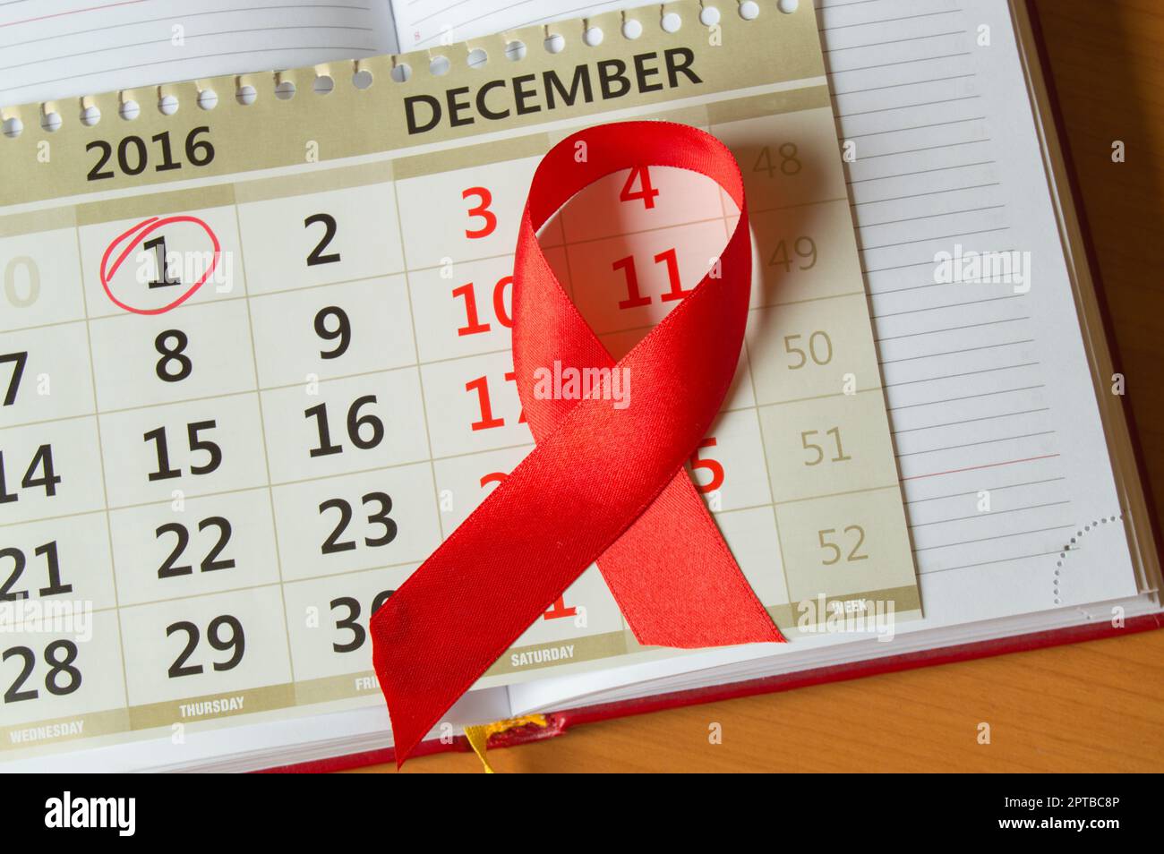 Red ribbon on the calendar to raise awareness against AIDS copy space ...