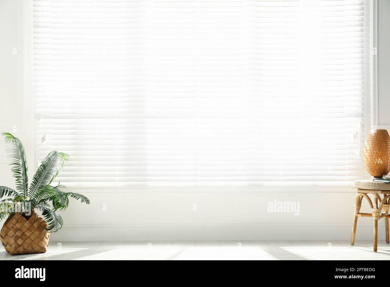 Stool, lamp and plant near big window in spacious room. Interior design ...