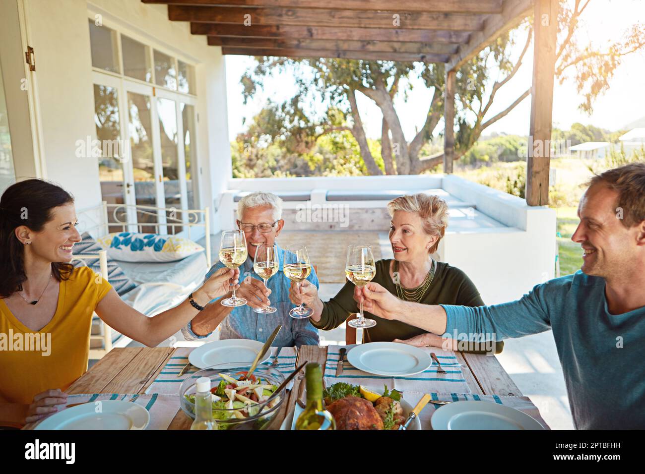 Lets toast to this delicious Sunday roast. a happy family toasting with ...