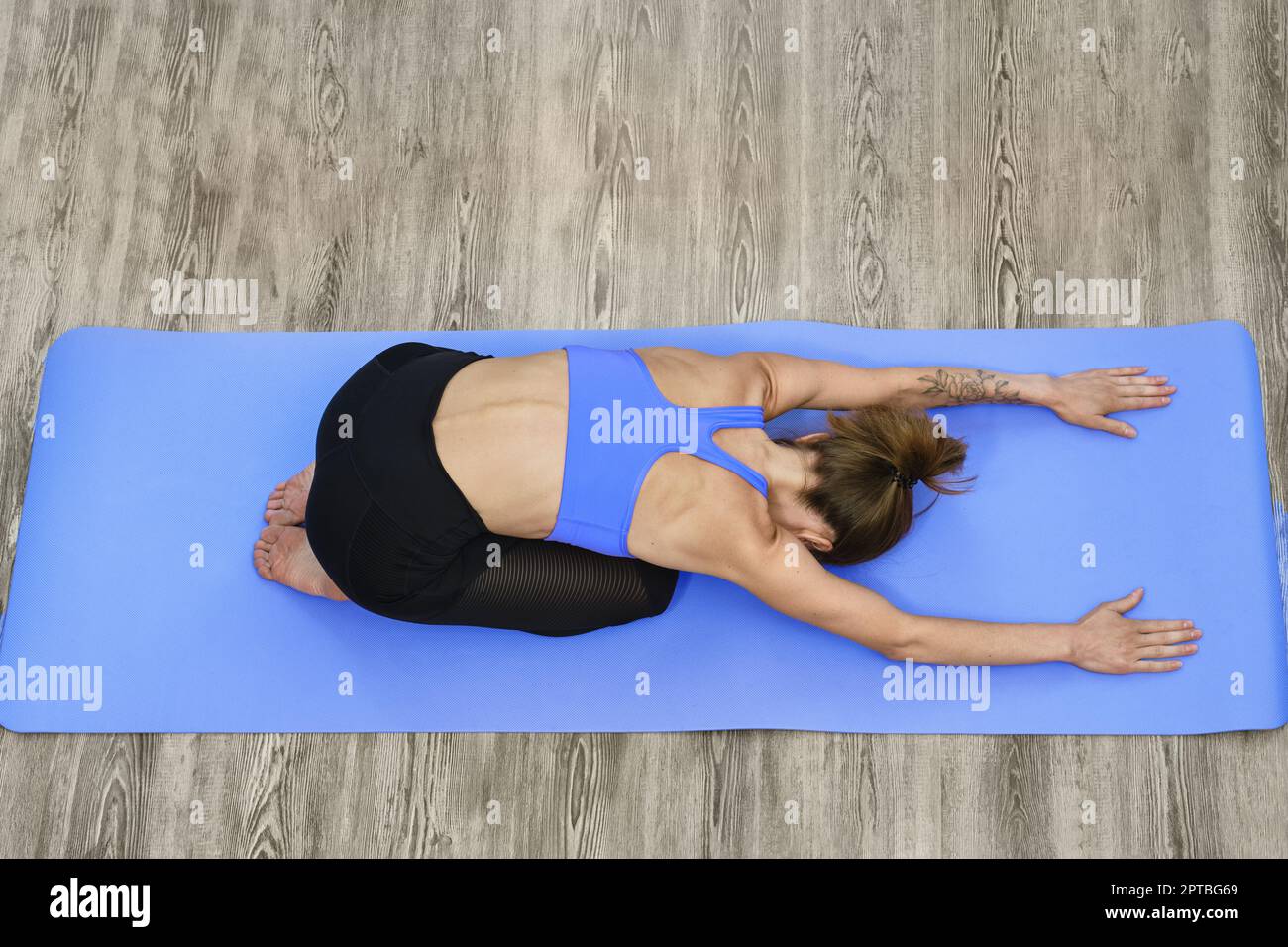 Top view of young woman does stretching exercises on the floor Stock ...