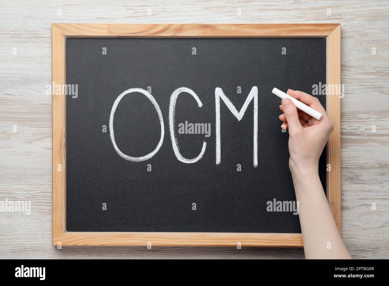 Woman writing abbreviation OCM (Organizational Change Management) on ...